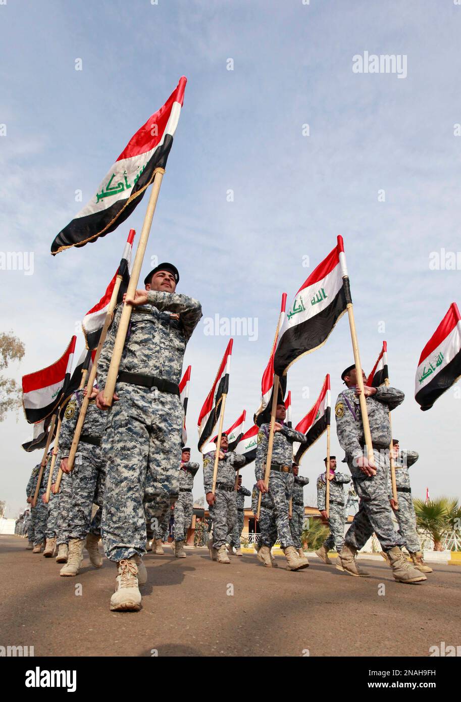 Iraqi federal police graduates march holding national flags during a ...