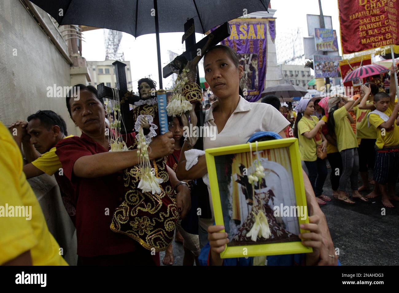 Filipino devotees hold images of Jesus Christ during a procession for ...