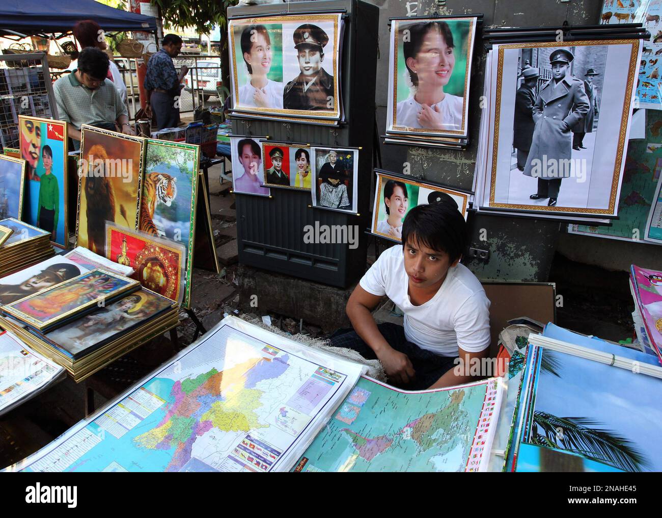In this photo taken Jan 6, 2012, a Myanmar man sells maps and posters ...