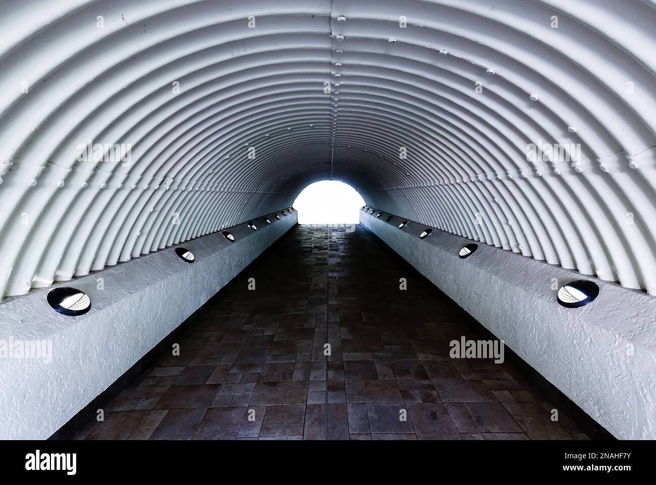 Underground tunnel walkway with bright light at the end Stock Photo - Alamy