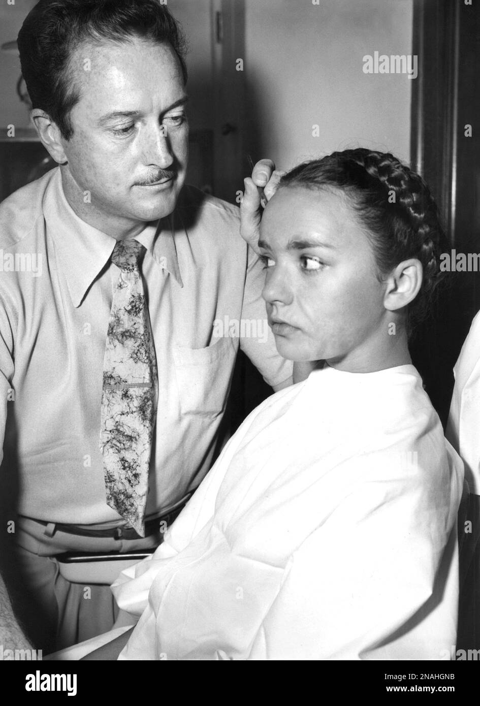 Makeup man Gordon Bau brushes on rubber cement to seal down small plastic patches which ages 11 ...