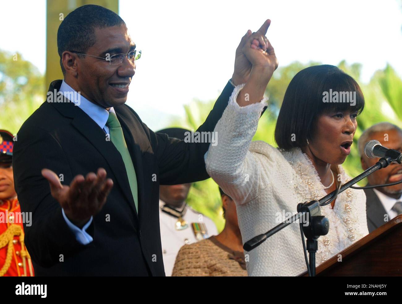 Jamaica's Prime Minister Portia Simpson Miller, right, holds hands with ...