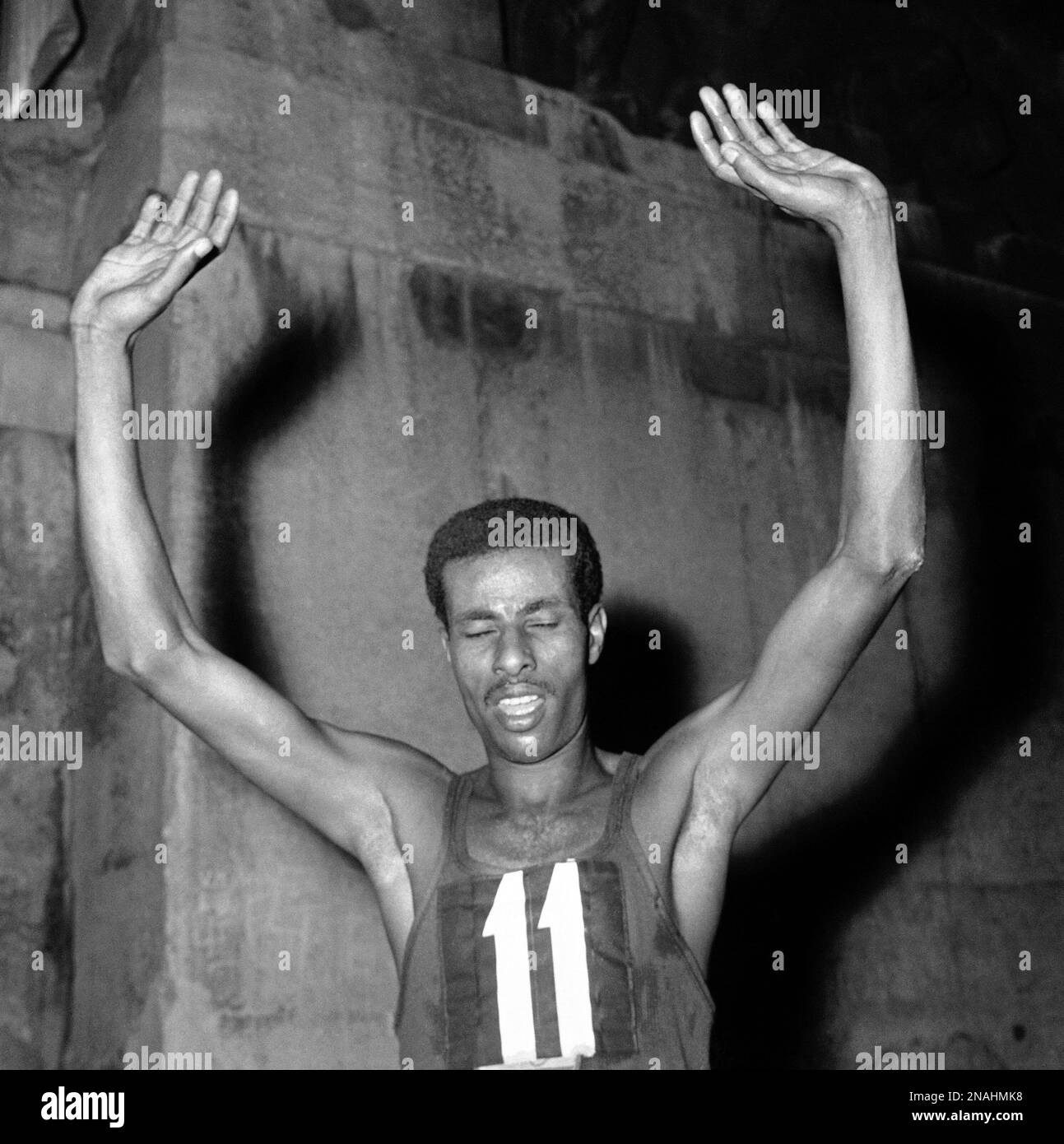 Ethiopian runner Bikila Abebe waves to cheering crowd and photographers ...