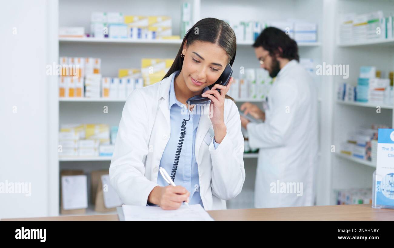 Pharmacist woman answering the telephone and giving advice to customer on flu shot treatment ...