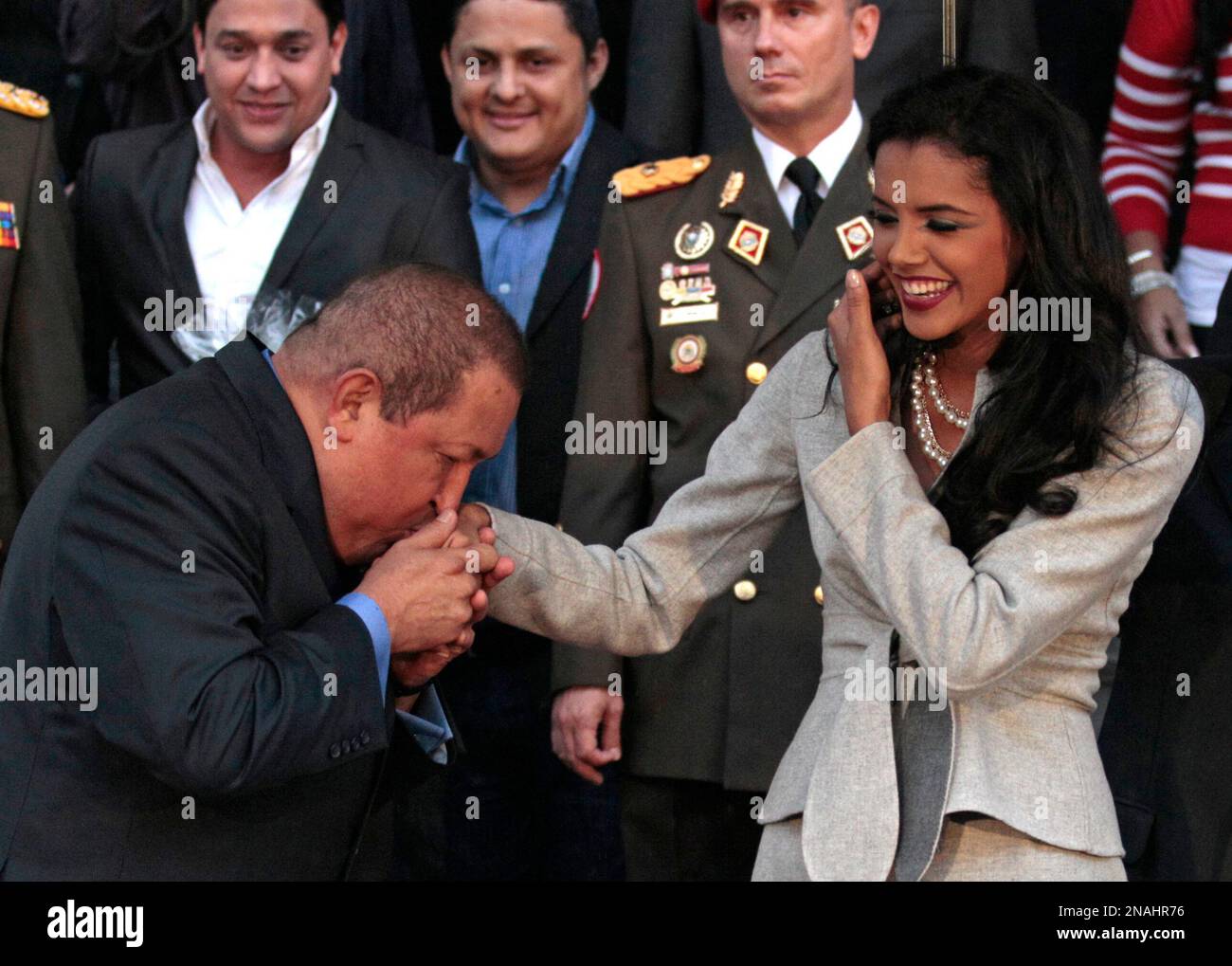Venezuela's President Hugo Chavez, left, plants a kiss on the hand of ...