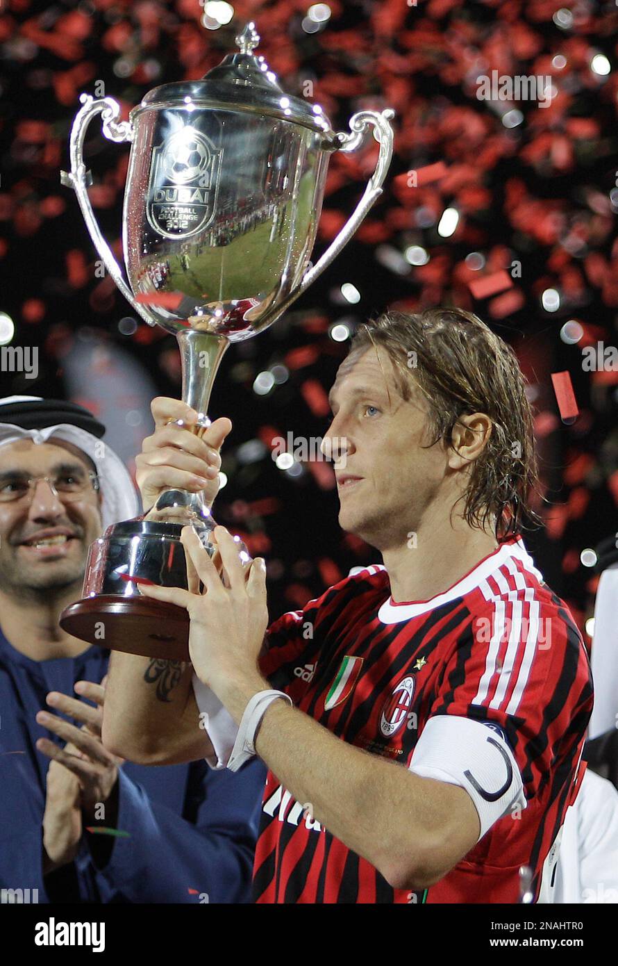 AC Milan's captain Massimo Ambrosini holds the trophy after they won ...