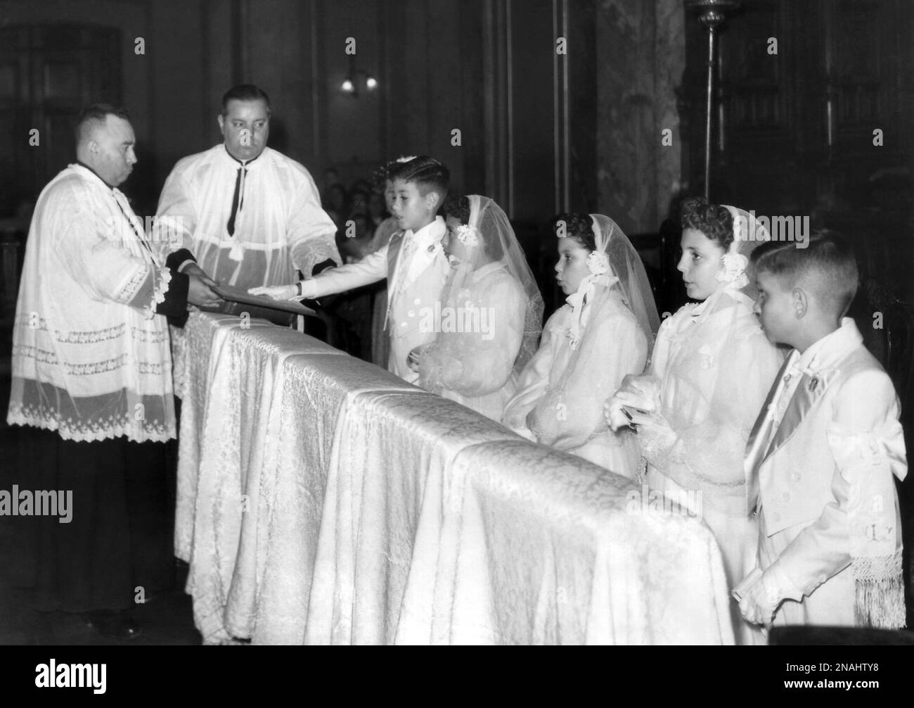 Garbed in white, the nine-year-old Diligenti quintuplets prepare to ...