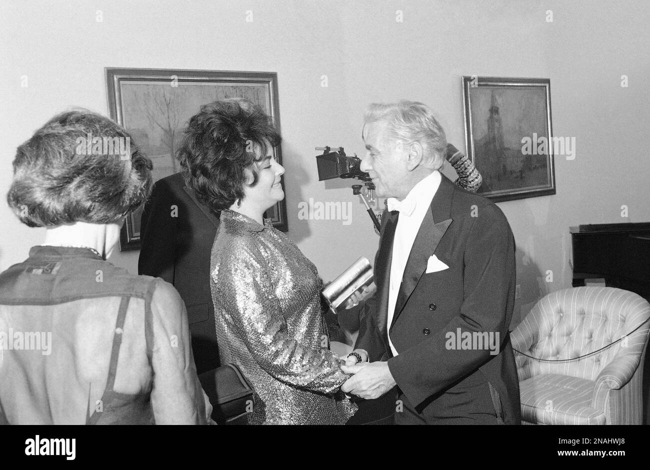 Actress Elizabeth Taylor chats with conductor Leonard Bernstein ...