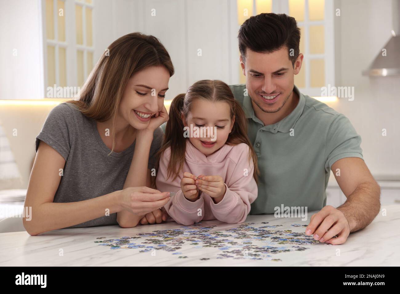 Happy family playing with puzzles at home Stock Photo - Alamy