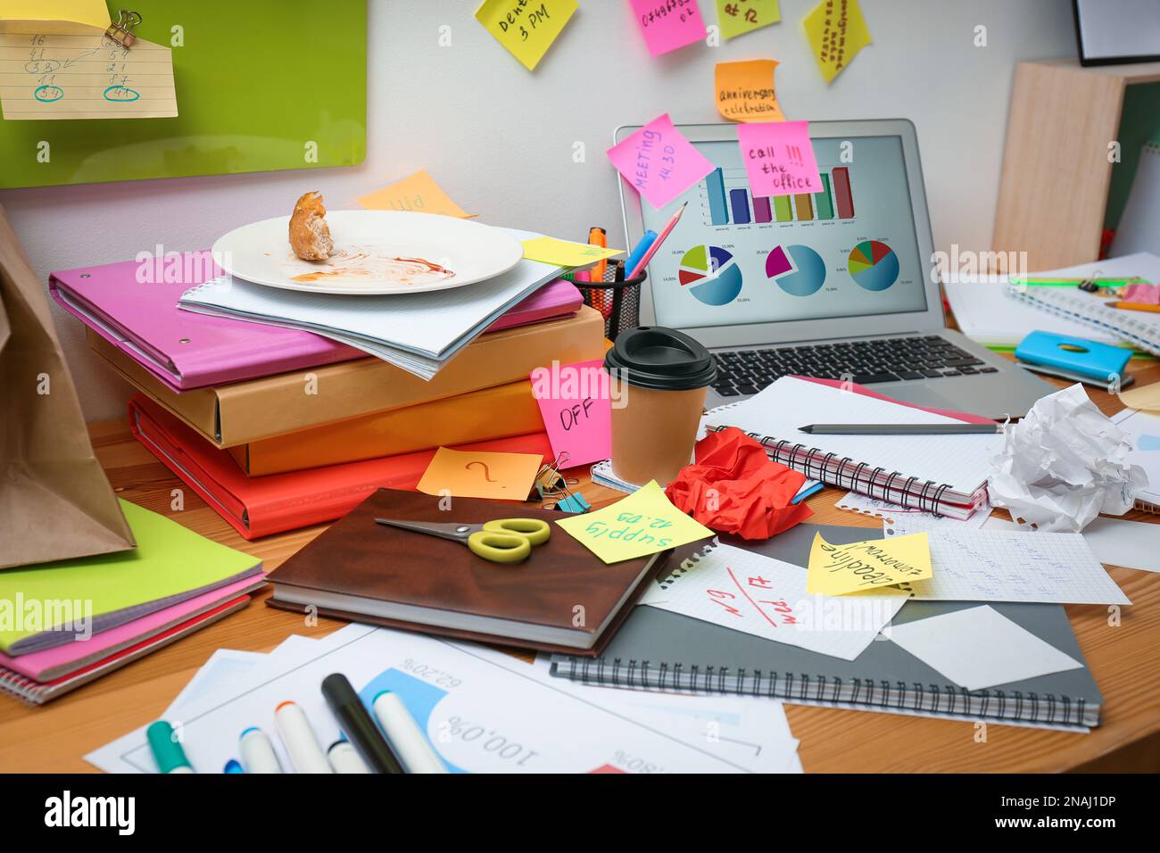 Messy table with laptop and stationery. Concept of being overwhelmed by ...