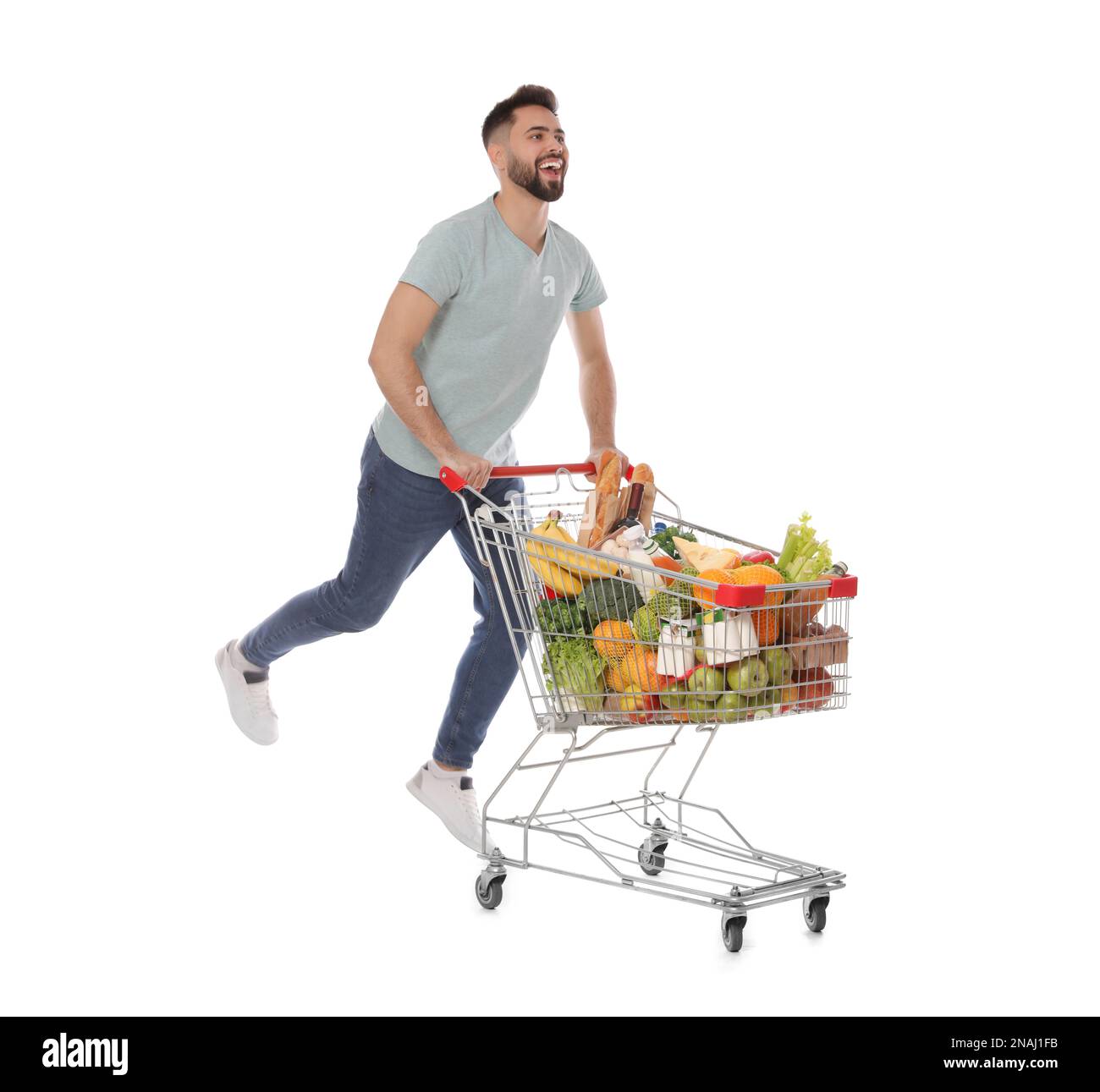 Happy man with shopping cart full of groceries on white background ...