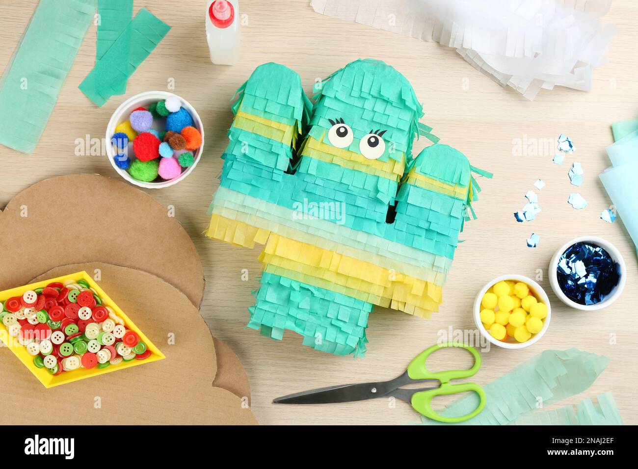 Flat lay composition with cardboard cactus on wooden table. Pinata diy ...
