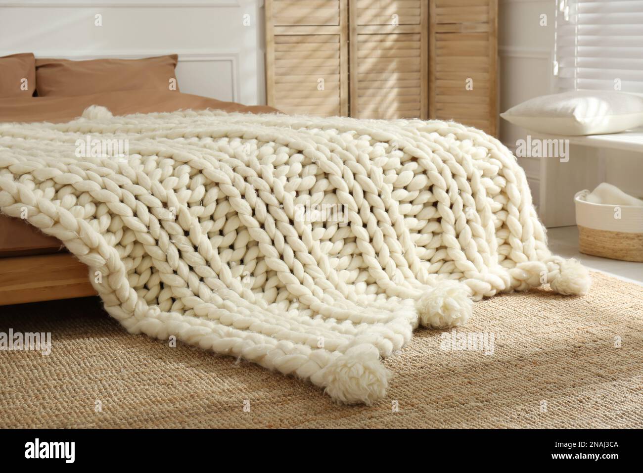 Knitted merino wool plaid on bed indoors. Interior design Stock Photo ...