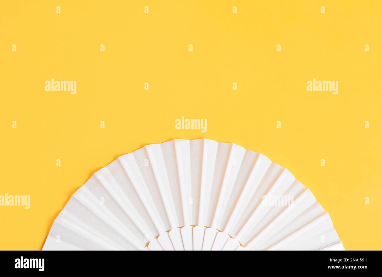 White hand fan on yellow background, top view. Space for text Stock ...