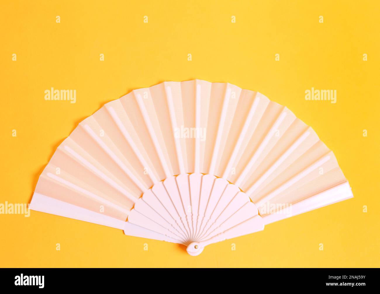 White hand fan on yellow background, top view Stock Photo - Alamy
