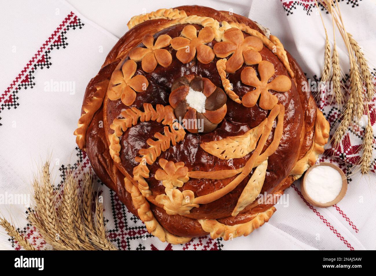 Korovai with wheat spikes on rushnyk, flat lay. Ukrainian bread and ...