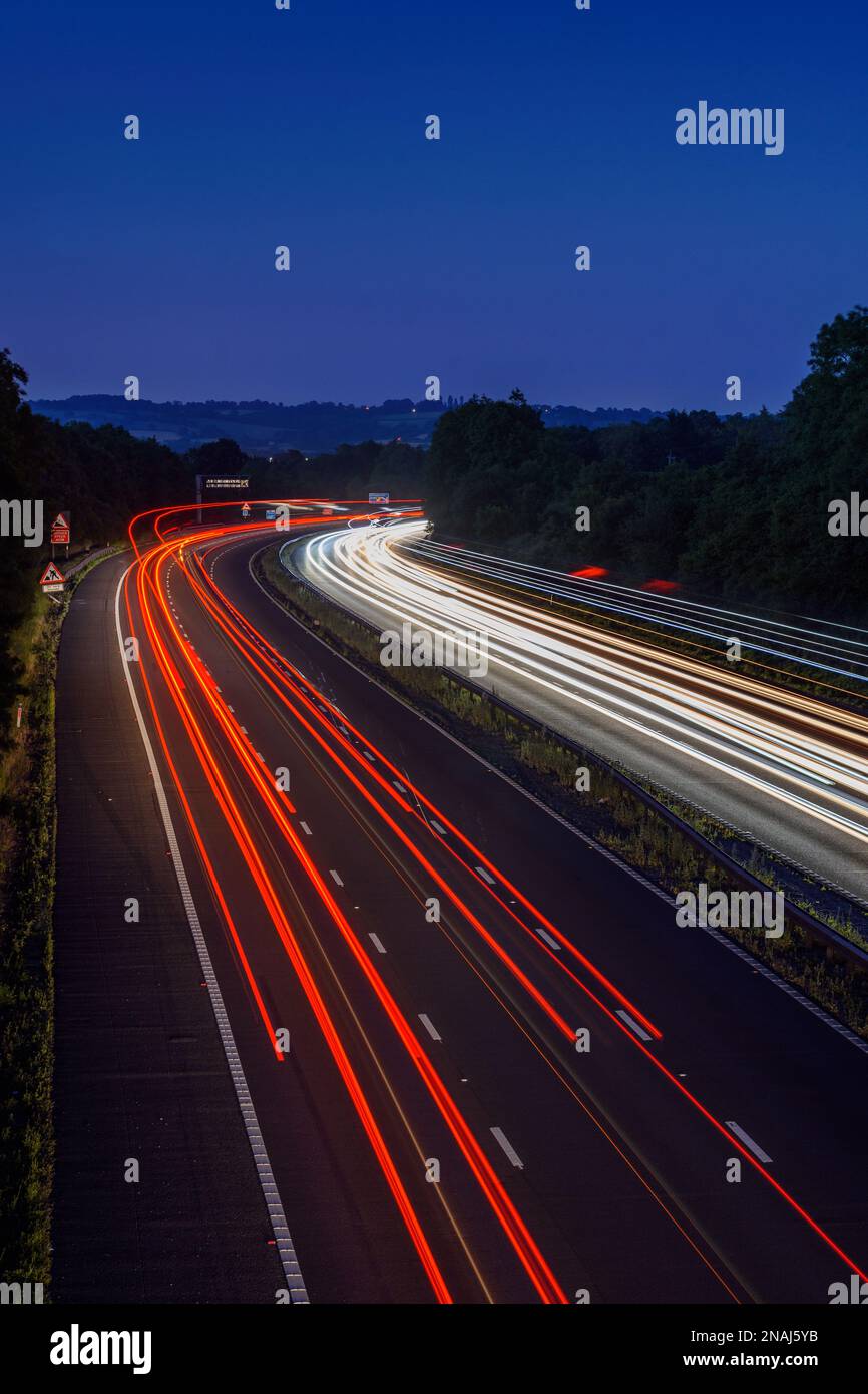 The fast moving cars on the M5 highway leave traffic light trails and ...