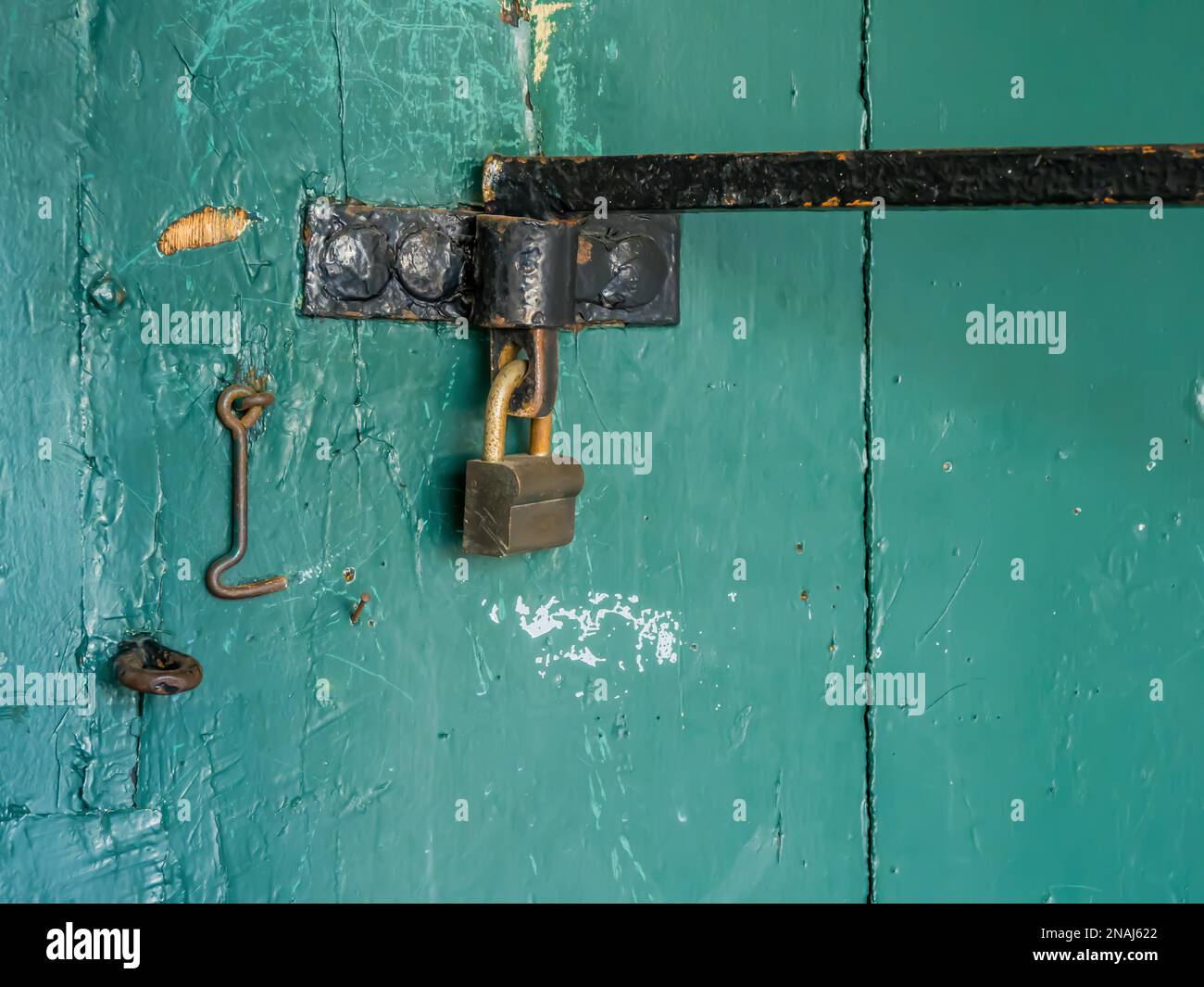 An old turquoise door is secured by a padlock Stock Photo - Alamy