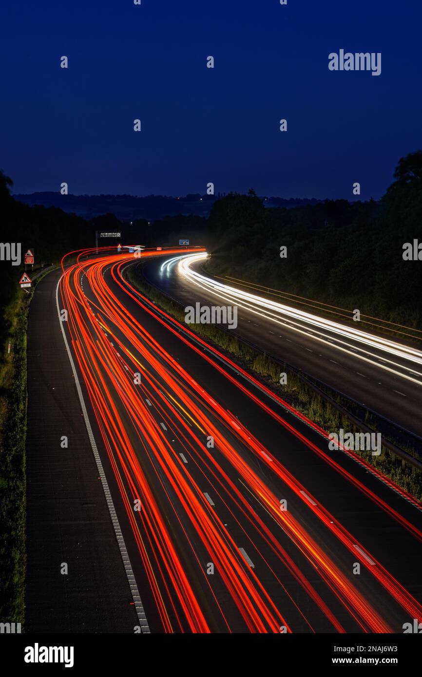 The fast moving cars on the M5 highway leave traffic light trails and ...