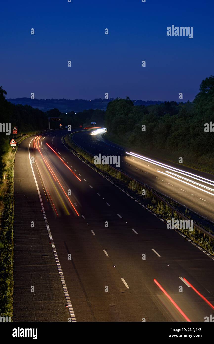 The fast moving cars on the M5 highway leave traffic light trails and ...