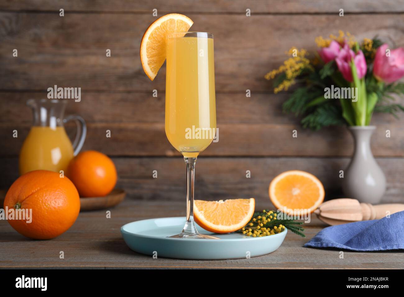 Glass of Mimosa cocktail with garnish on wooden table Stock Photo - Alamy