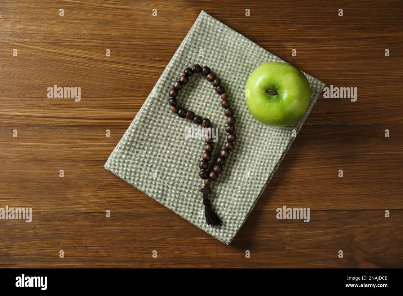 Rosary beads and apple on wooden table, top view. Lent season Stock ...