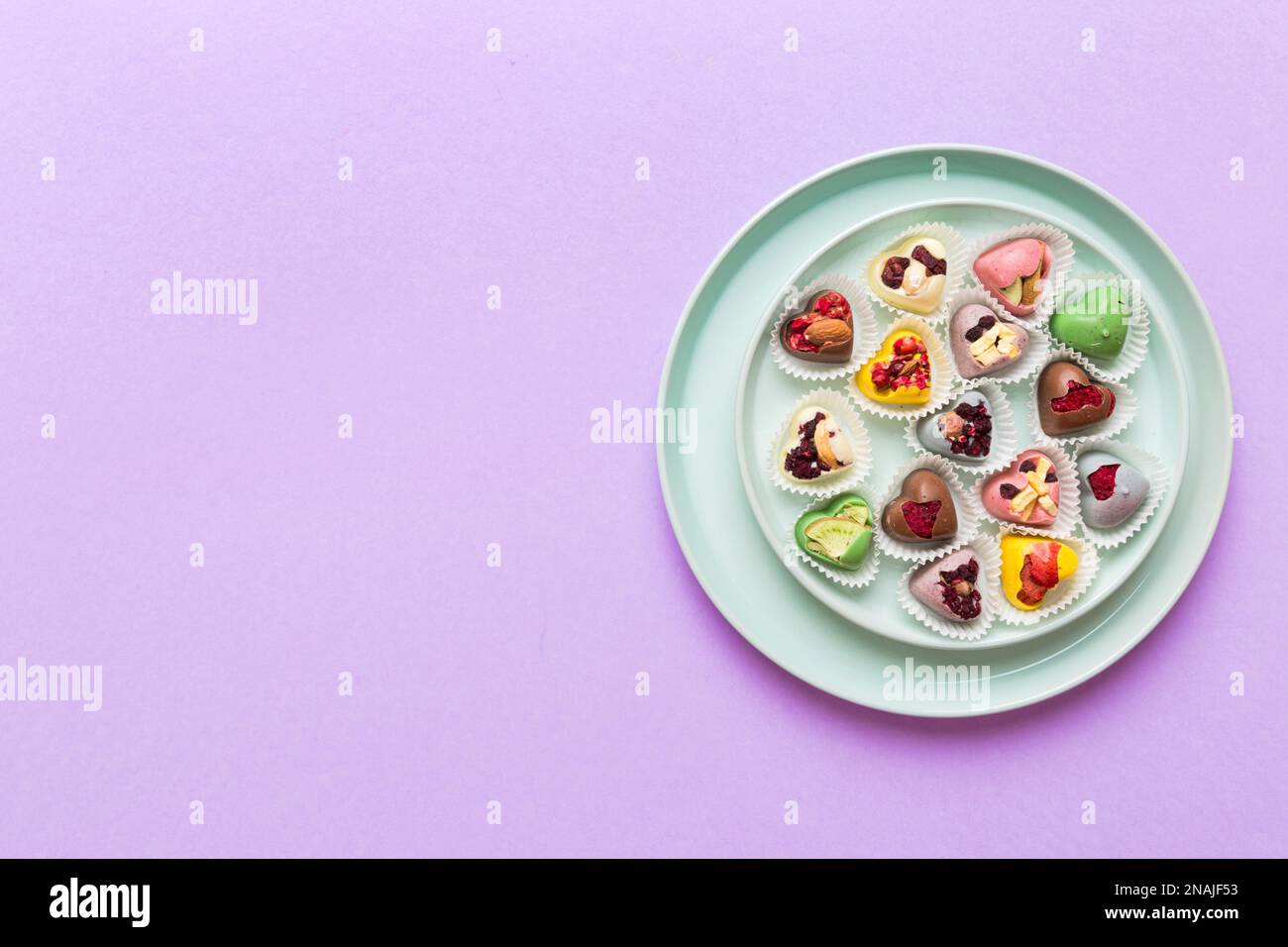 Plate with different chocolate on colored background. Assortment of ...