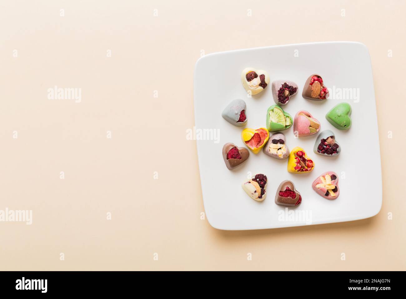 Plate with different chocolate on colored background. Assortment of ...