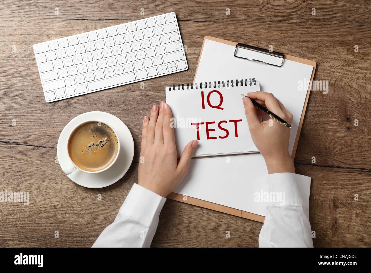 IQ Test. Woman with pen and notebook at wooden table, top view Stock ...