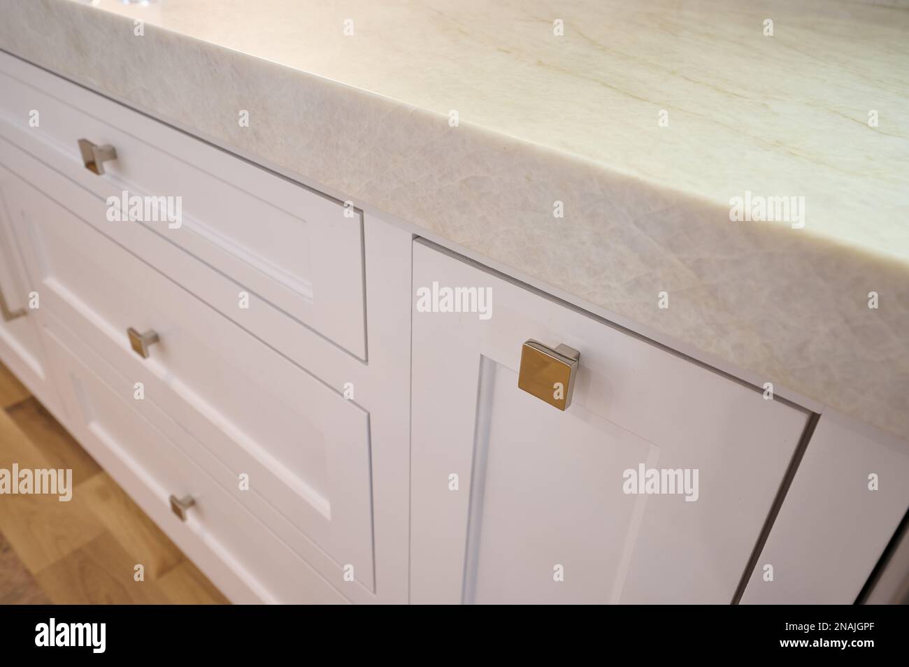 Closeup angled view of contemporary cabinet hardware and countertop ...