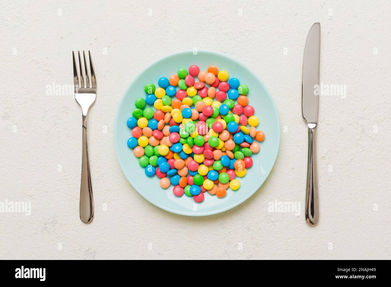 cutlery on table and sweet plate of candy. Health and obesity concept ...