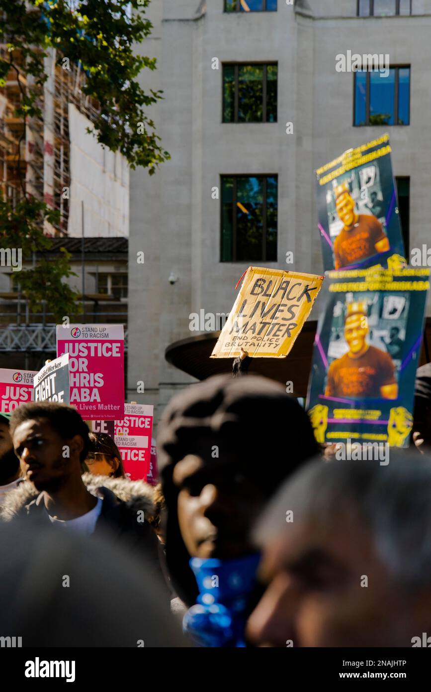 The crowd members holding placards saying "justice for Chris" around ...