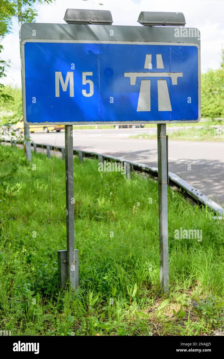 A blue street sign informs drivers the road they are driving on is the ...