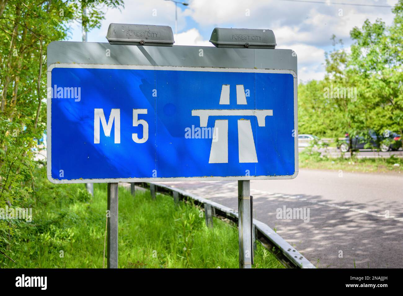 A blue street sign informs drivers the road they are driving on is the ...