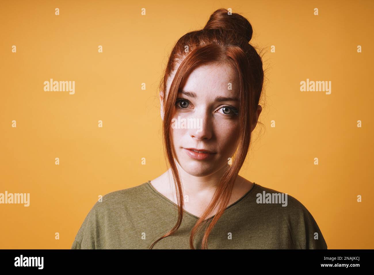 cool young woman with red hair messy bun hairstyle and loose strands at ...