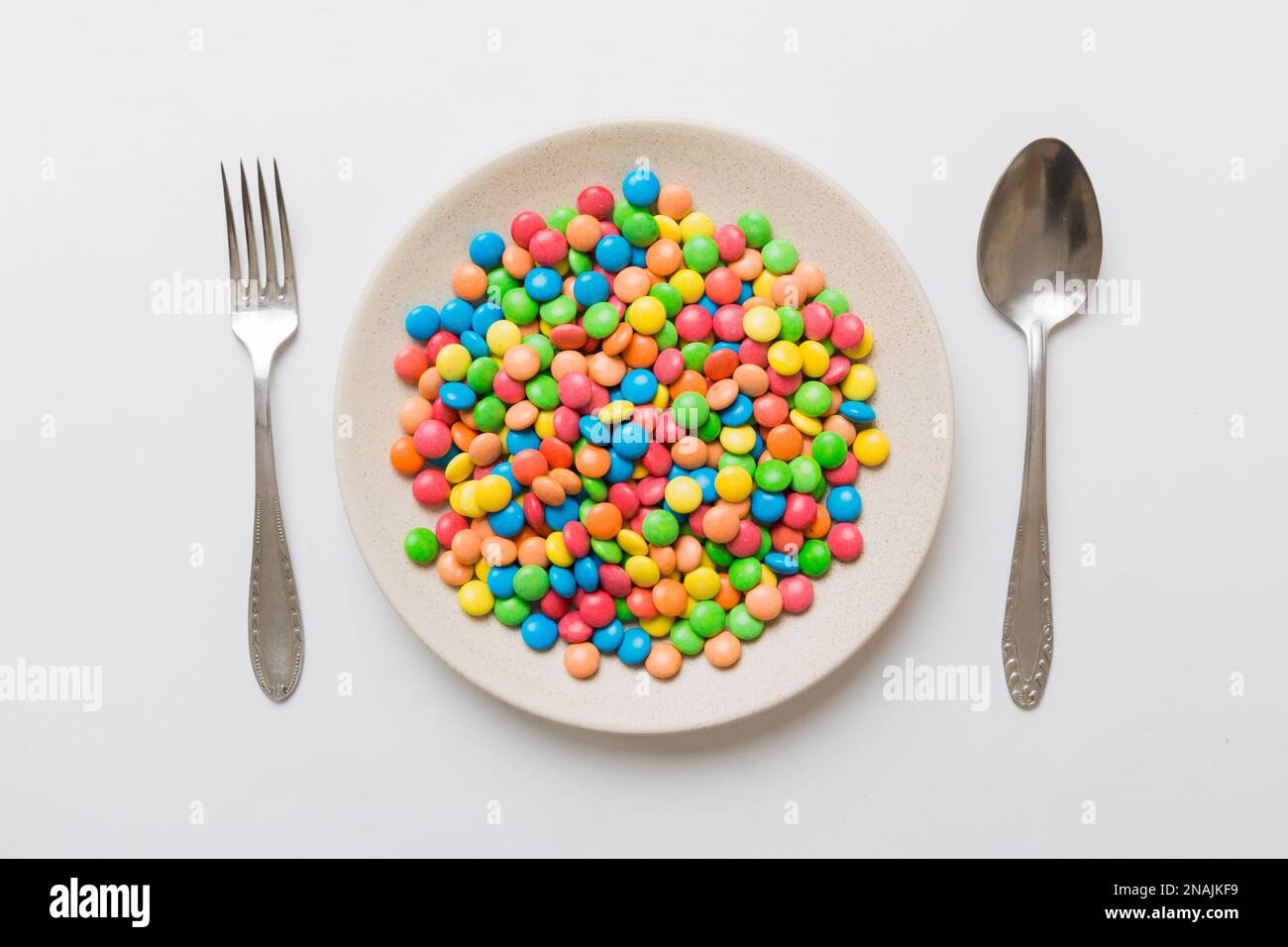 cutlery on table and sweet plate of candy. Health and obesity concept ...