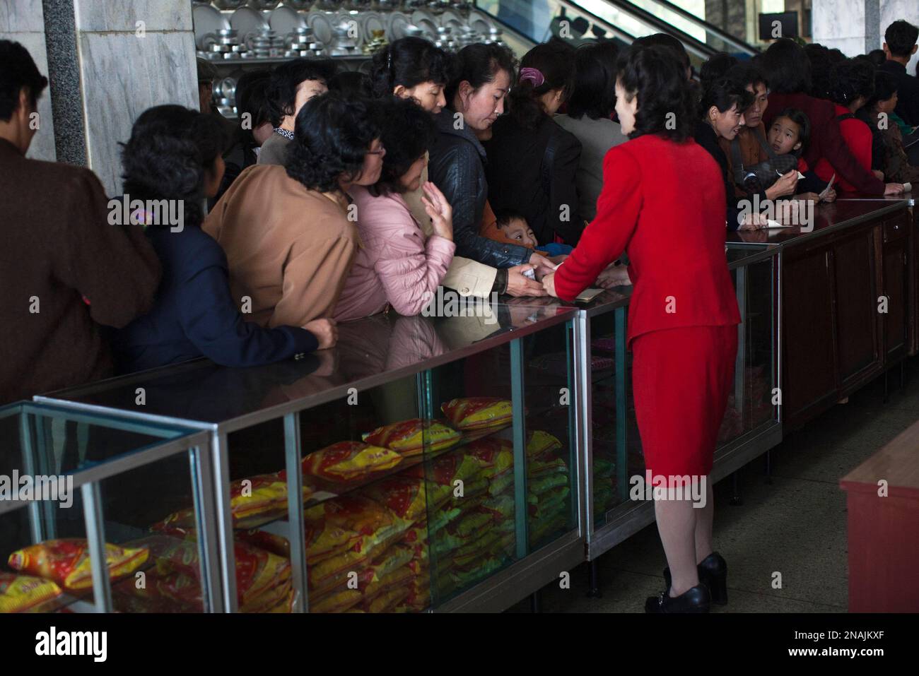 In this Sunday Oct. 9, 2011, a North Korean cashier helps customers at ...