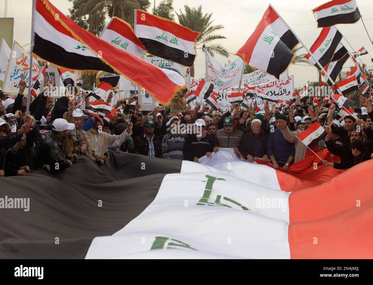 Protesters chant anti-US slogans and wave Iraqi flags during a ...