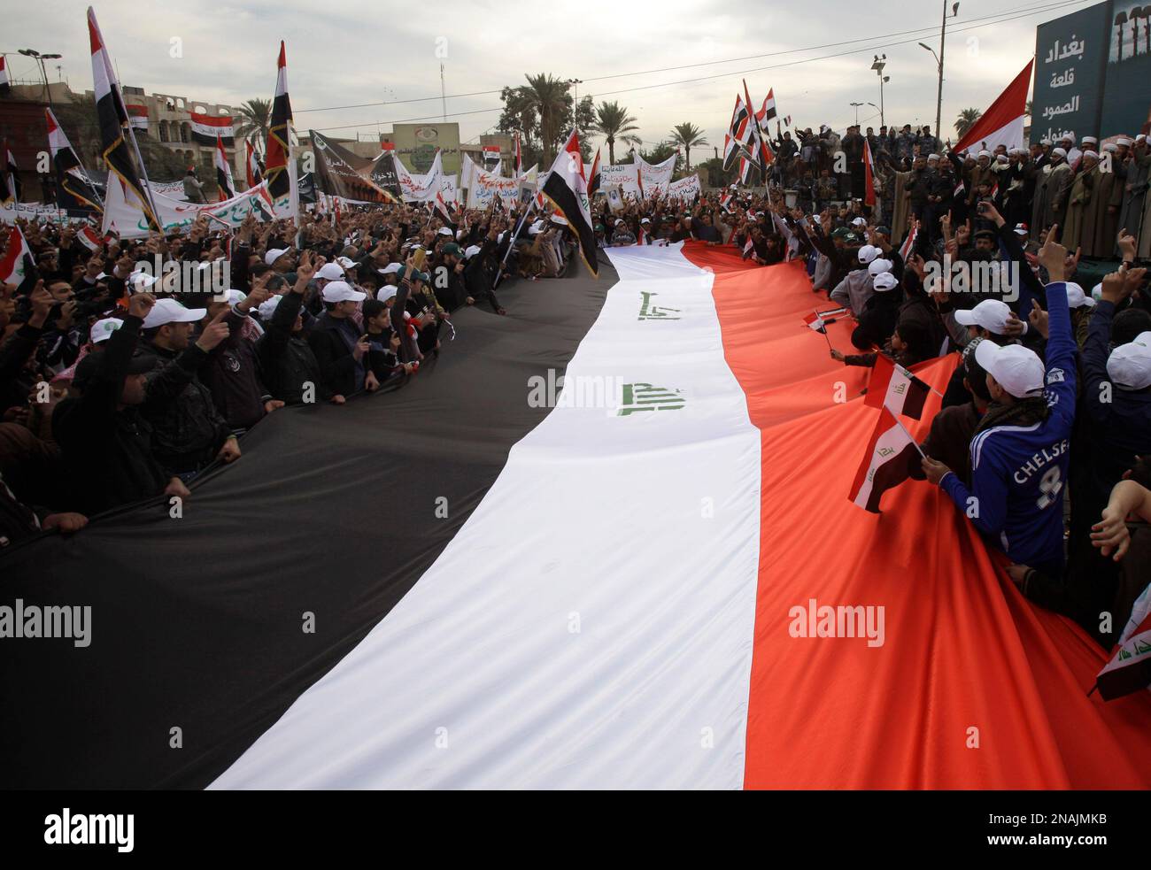 Protesters chant anti-US slogans and wave Iraqi flags during a ...