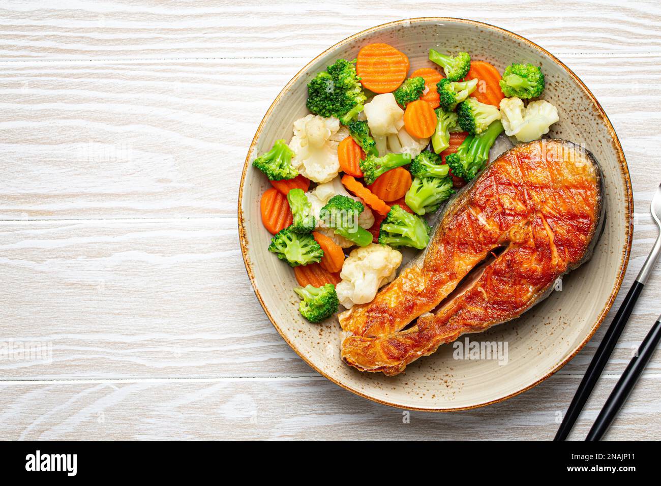 Healthy fish dinner: grilled salmon fish steak with vegetables salad on ...
