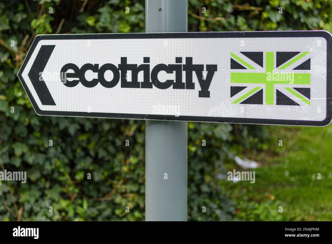 A sign directs drivers to an Ecotricity electric vehicle charging point ...