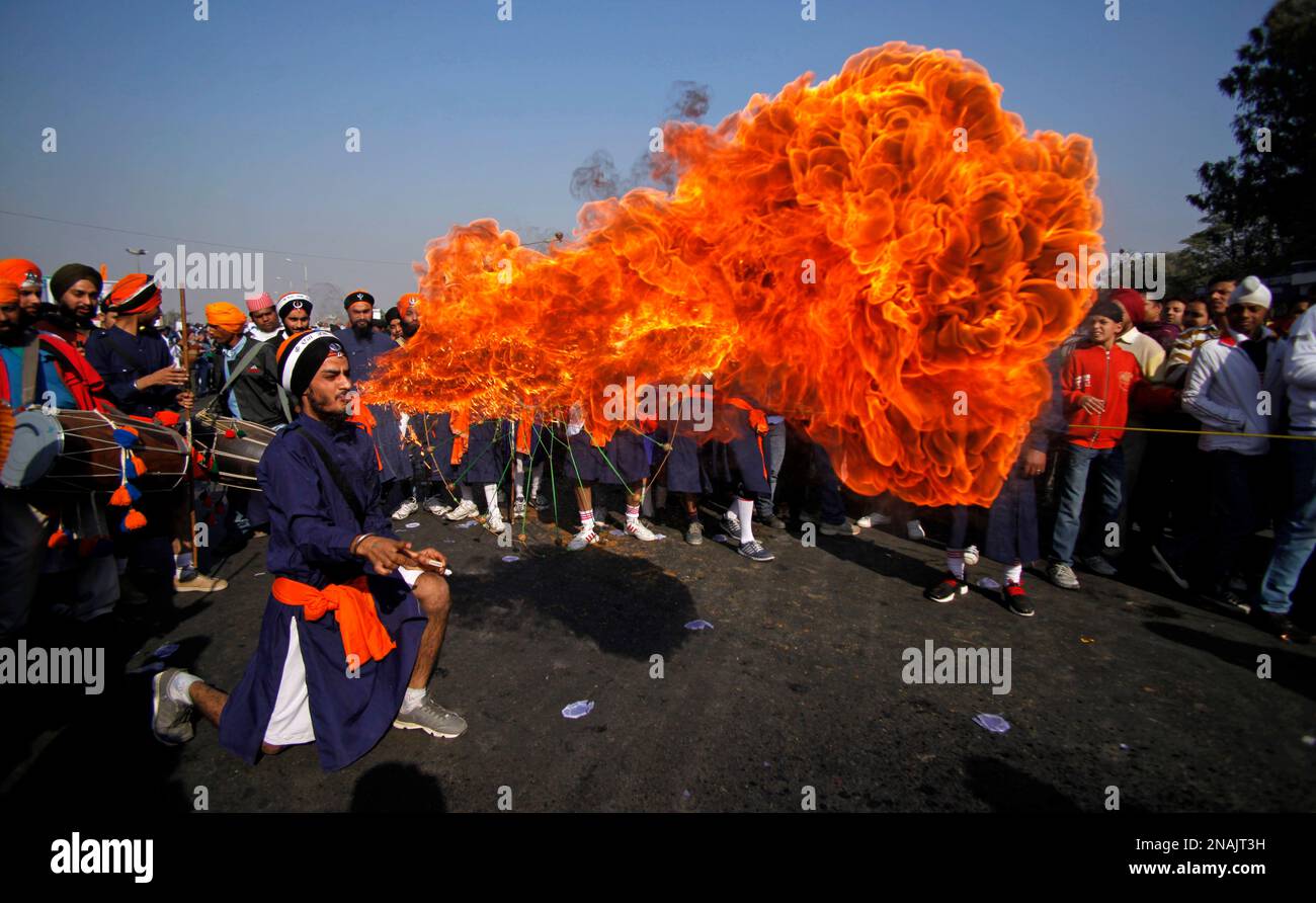 A Sikh warrior blows fire from his mouth during a religious procession ...