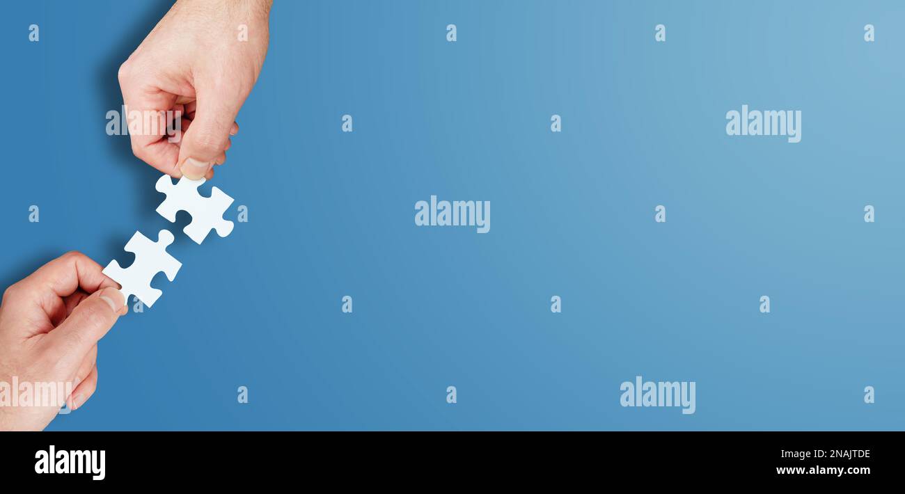 hands of two people putting together two jigsaw puzzle pieces, finding ...