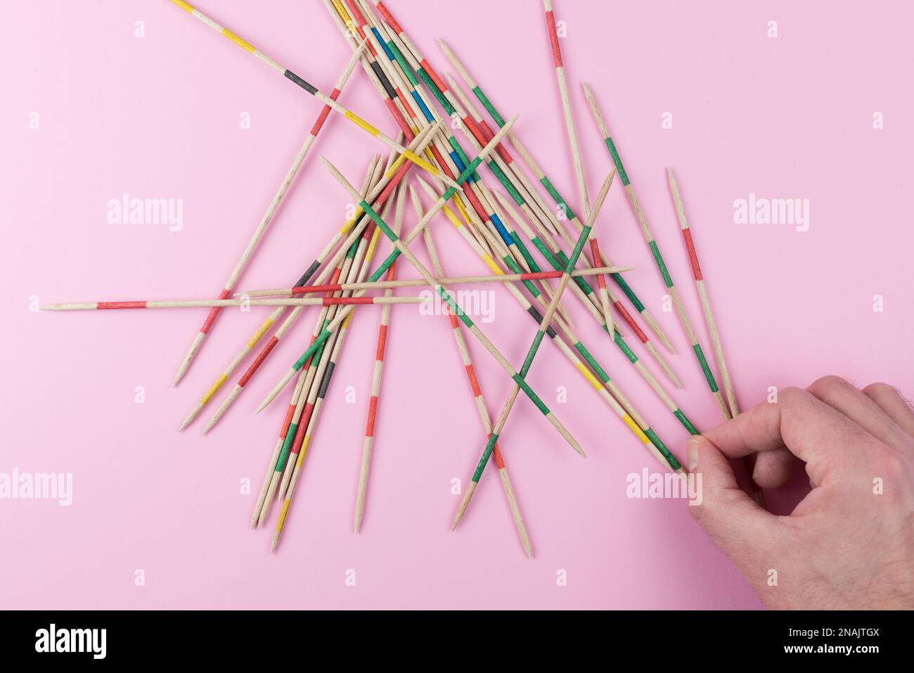 top view of hand of person trying to pick up mikado stick, game of ...