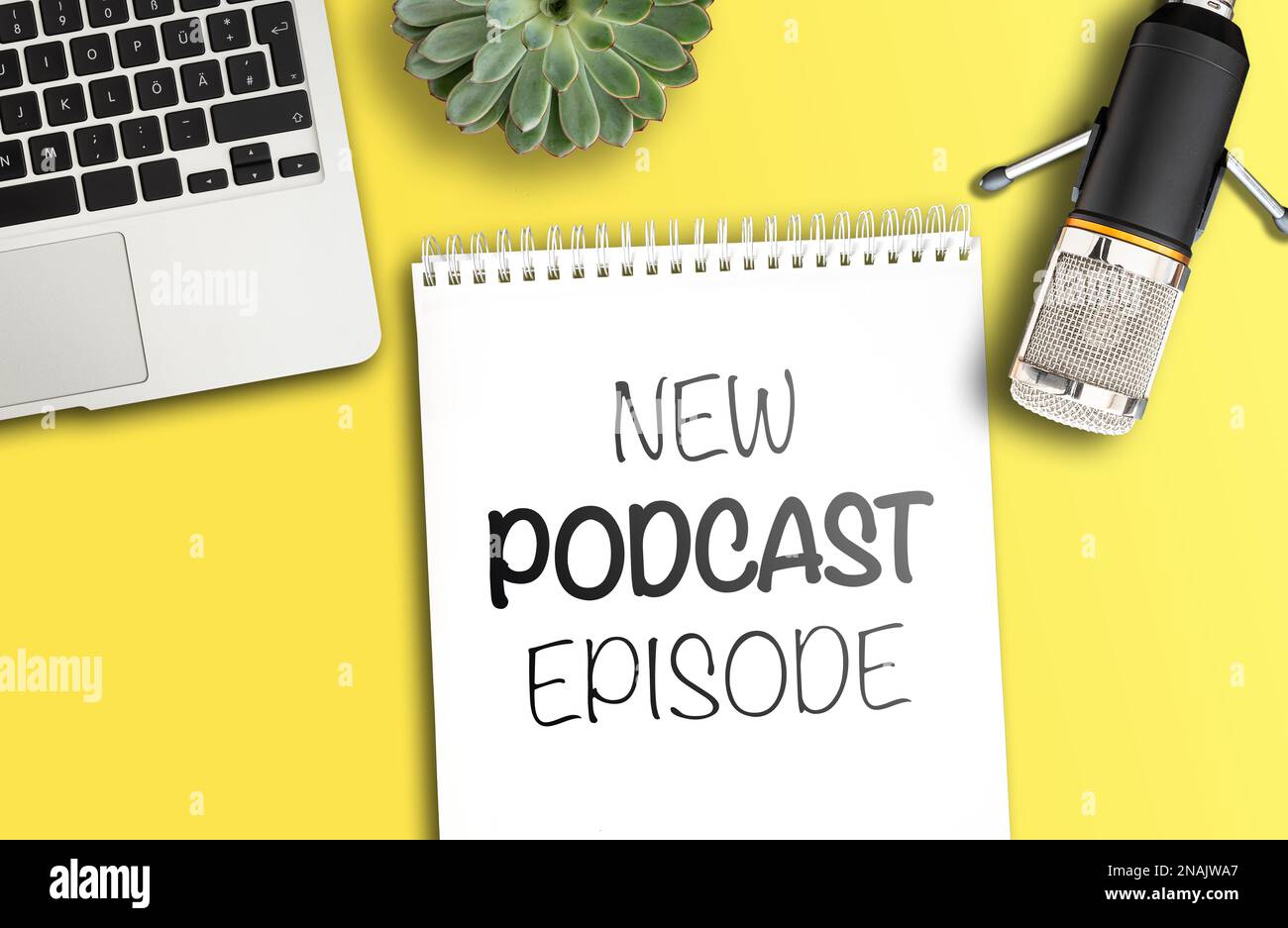 top view of text NEW PODCAST EPISODE on notepad on desk with microphone ...