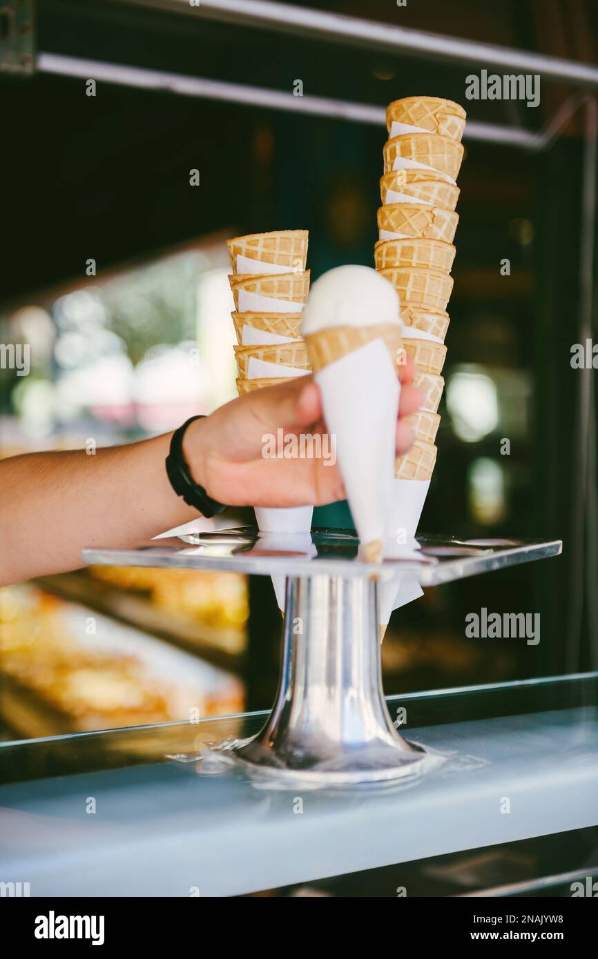Seller offering defocused blur waffle cone with yoghurt ice-cream on ...
