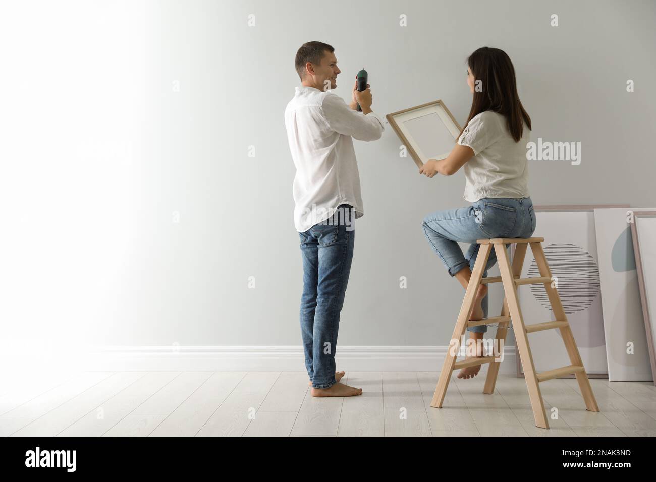 Couple decorating room with picture together. Interior design Stock ...
