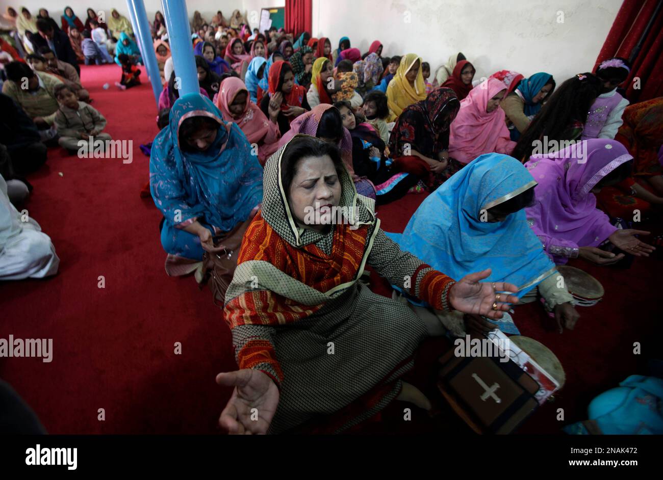 Pakistani women pray during a Christmas mass in a Christian ...