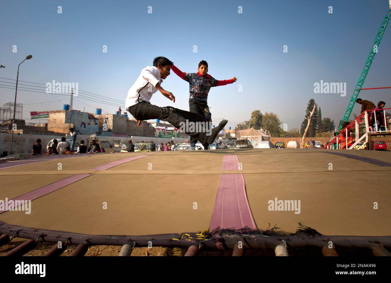 Pakistani Christian boys enjoy jumping on a trampoline at a Christian ...