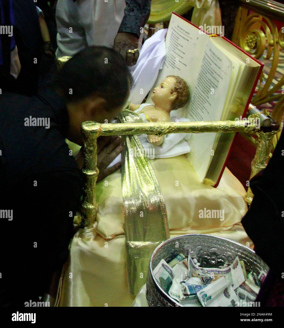 A Myanmar Christian prays in front of a statue of baby Jesus during the ...